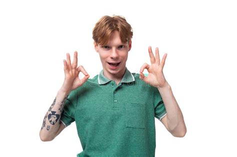 Joyful Happy Young Redhead Guy In Green Shirt Looking At Camera Stock