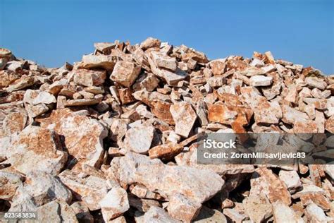 화강암은 갈색 건설 및 여름 시간에 푸른 하늘 아래 더미에 쌓여 바위 바위의 큰 더미 채 석 장에서 석회석의 큰 더미입니다 자갈