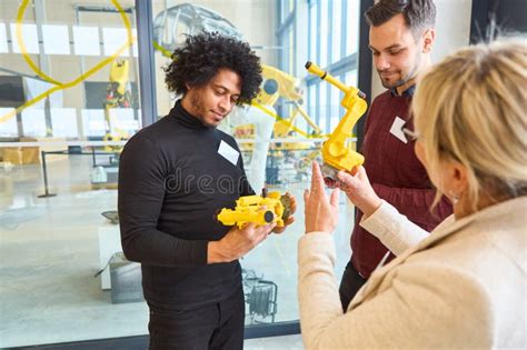 engineers discussing and programming robotic arms for industrial