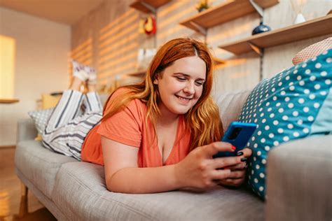집에서 스마트 폰으로 소셜 미디어를 확인하는 젊은 여성 과체중에 대한 스톡 사진 및 기타 이미지 과체중 소파 한 명의 여자만 Istock