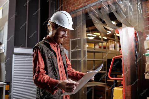 Premium Photo Side View Portrait Of Bearded Worker Wearing Hardhatat Factory And Looking At
