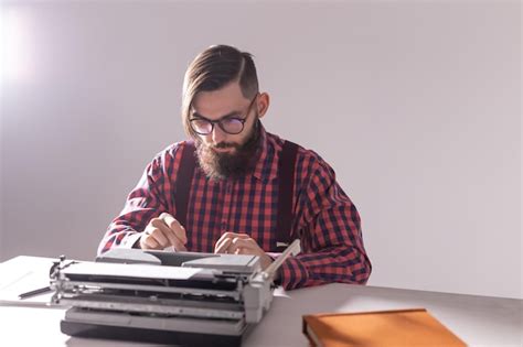 Joven Sentado En La Mesa Contra Un Fondo Gris Foto Premium