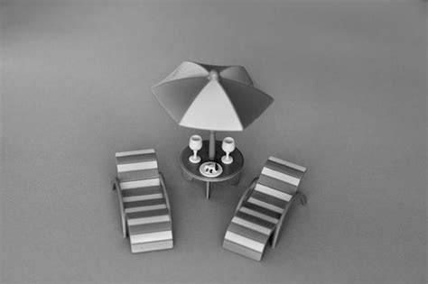 해변의 녹색 나뭇잎 아래 두 개의 안경과 테이블에 디저트와 태양 우산 아래 두 라운지 의자 일광욕 의자 안락의자 갑판 의자에 야자수 아래 여름 휴가 0명에 대한 스톡 사진