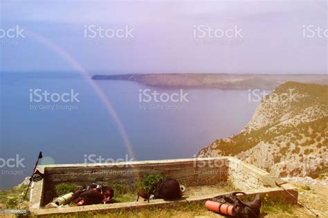 바다 풍경의 배경에 버려진 배낭 산에 관광객 물건에 의해 왼쪽 캠페인 배낭에 남아 있고 막대기는 여행자를 떠났습니다 바다를 따라 산 하이킹 고요한 장면에 대한 스톡 사진 및