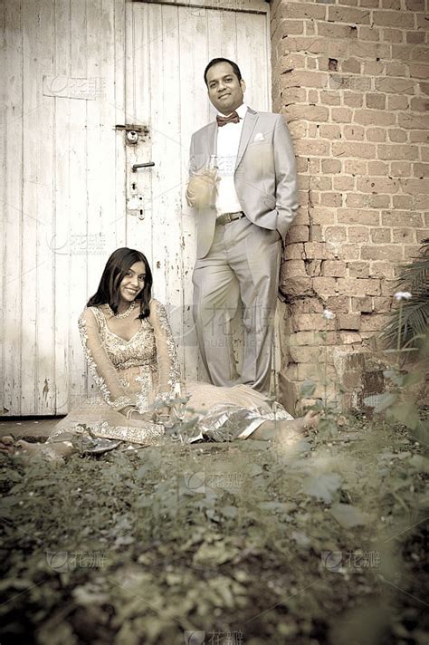 年轻迷人的印度夫妇在户外白色木门旁