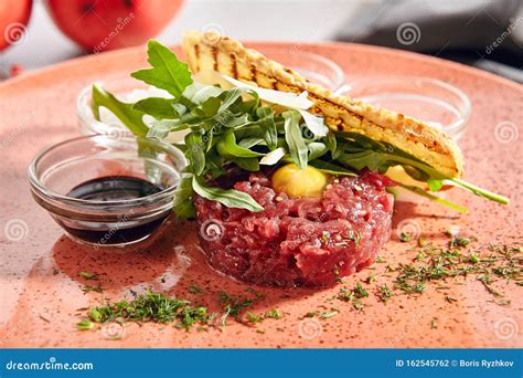 Steak Tartare Made From Raw Ground Beef With Greens Close Up Stock
