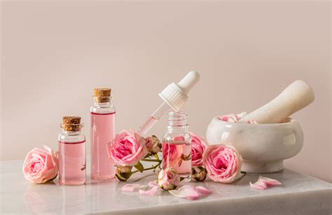 베이지색 배경에 작은 장미 꽃봉오리 사이에 다양한 병에 담긴 장미 기름을 기반으로 한 화장품 세트 복사 공간입니다 가정 간호 아로마 테라피에 대한 스톡 사진 및 기타 이미지
