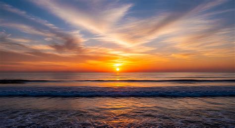 Stunning Golden Sunset Over The Ocean With Vibrant Skies And Gentle