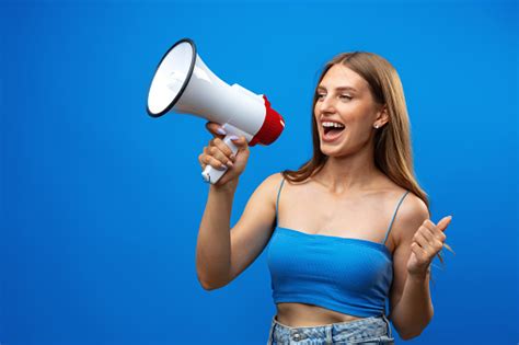 스튜디오에서 파란색 배경에 대해 메가폰을 가진 젊은 예쁜 여자 20 24세에 대한 스톡 사진 및 기타 이미지 20 24세