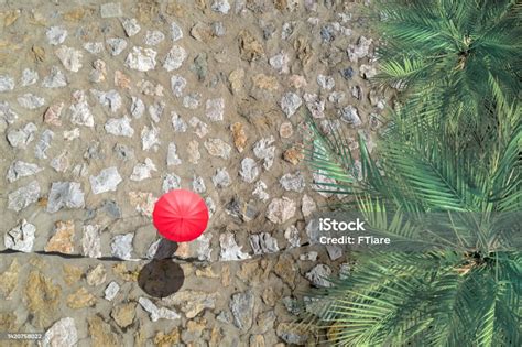 붉은 비 우산을 가진 여성이 여름날 태양으로부터 자신을 보호하는 포장 된 돌 길을 걷고 있습니다 상단 드론 조감도 35 39세에 대한 스톡 사진 및 기타 이미지 Istock