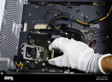Image Of A Technician Inserting A Cpu Chip Onto A Computer Motherboard
