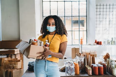 푸드 뱅크에서 음식과 음료의 골판지 상자를 들고 혼합 인종 자원 봉사 여성의 초상화 자선 및 구제 사업에 대한 스톡 사진 및 기타 이미지 자선 및 구제 사업 자선기부