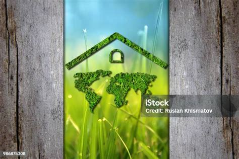 지구의 날입니다 생태 개념입니다 자연 개념입니다 지붕 아래 세계의 녹색 지도 오염 및 오래 된 나무 울타리를 통해이 슬 방울과 배경 신선한 녹색 봄 잔디에 산업 폐기물