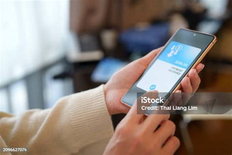 스마트폰을 들고 있는 여성의 손이 결제 수령이라는 메시지를 보여주는 이미지를 잘라 모바일 기기를 통해 이루어지는 금융 거래의 개념을 보여줍니다 45 49세에 대한 스톡 사진