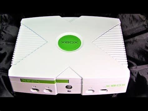 A Close Up Of A White Xbox Box On A Black Cloth Covered Surface With