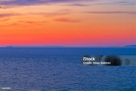 여러 가지 빛깔의 지층 구름을 배경으로 바다의 일몰을 한눈에 볼 수 있습니다 추상적인 반성 휴식 디자이너를 위한 공백 시각적 이미지 독특한 순간을 위한 자연스러운 배경 0