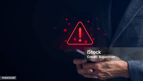 삼각형 주의 경고 기호가 있는 스마트폰을 들고 있는 사업가 또는 사용자는 알림 오류 및 유지 관리 개념에 대해 빨간색으로 표시됩니다 경고 표시 느낌표 알림 아이콘에 대한