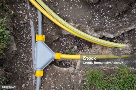 케이블 3개 라인의 지하 연결 전기 인프라 설치 튜브로 보호되는 케이블이 있는 건설 현장 전기 및 고속 인터넷 네트워크 케이블이 묻혀 있습니다 0명에 대한 스톡 사진 및