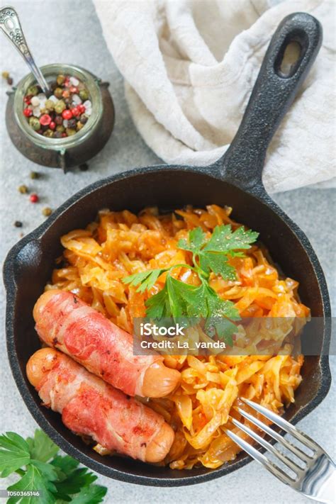 당근 양파와 토마토 파 슬 리와 베이컨에 Saucages와 무 쇠 냄비에 향신료와 함께 조 림된 양배추 Bigos입니다 맛 있는 점심 식사 0명에 대한 스톡 사진 및 기타