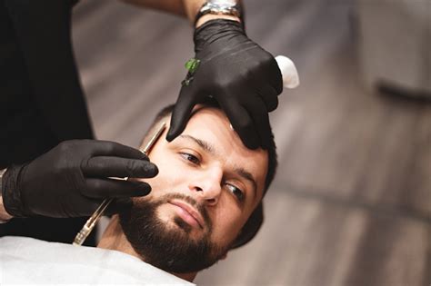 위험한 면도기로 이발소에서 수염을 면도합니다 이발소 수염 관리 건조 절단 수염 절단 선택적 초점 개인 장식품에 대한 스톡 사진