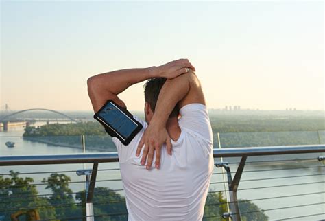 스포츠를하고 도시 다리에 서서 팔을 뻗고 아침 운동 중에 몸을 따뜻하게하는 운동 선수의 뒷모습 강에 대한 스톡 사진 및 기타 이미지 Istock