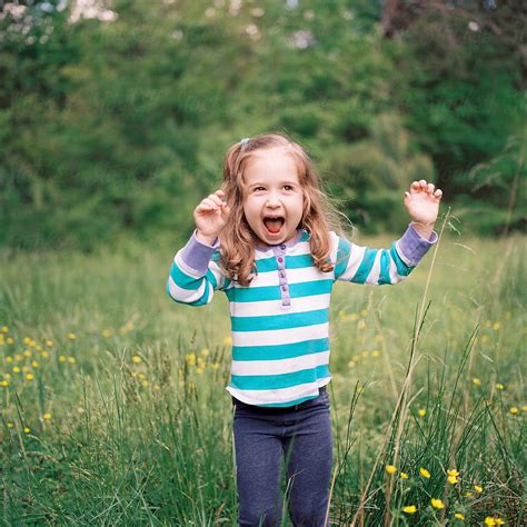 Cute Young Girl Acting Goofy In A Field By Stocksy Contributor Jakob