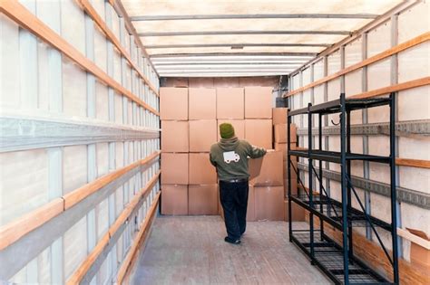 Premium Photo Worker Stacking Boxes On A Storage