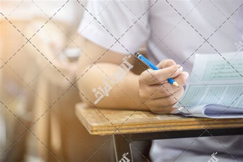 عکس دانش آموز روی صندلی کلاس در حال امتحان دادن