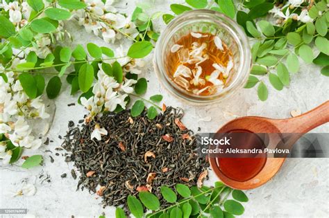 열매를 곁들인 말린 차 잎 유리 제품 컵에 아카시아 꽃국물 흰 시멘트 배경에 꿀을 곁들인 나무 숟가락 식물의 유용한 특성 0명에 대한 스톡 사진 및 기타 이미지 Istock