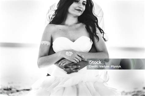 웨딩 커플은 바다 해변에서 포옹한다 화창한 여름 사진 오프 숄더 드레스 기차에서 머리를 숙인 신부 바다의 낭만적 인 의식 바닷가 러브 스토리 Mehndi 신부 헤나 디자인