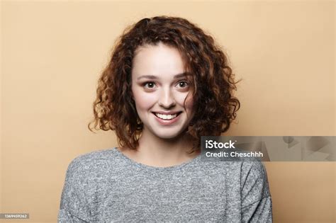 사람 행복 얼굴 표정 개념 귀여운 미소를 가진 예쁜 젊은 곱슬 여자는 베이지 색 배경에 대해 혼자 포즈 갈색 눈에 대한 스톡 사진 및 기타 이미지 Istock