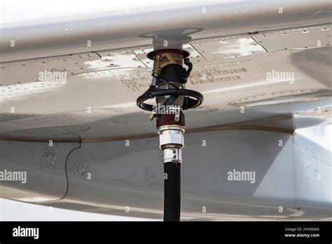 Aircraft Fueling Nozzle Attached To A Planes Refueling Port Showcasing Precision Refueling
