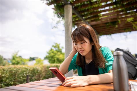 공공 공원에서 스마트 폰을 사용하여 녹색 가디건을 입은 일본 여성 30 34세에 대한 스톡 사진 및 기타 이미지 30 34세 Brand Name Smart Phone
