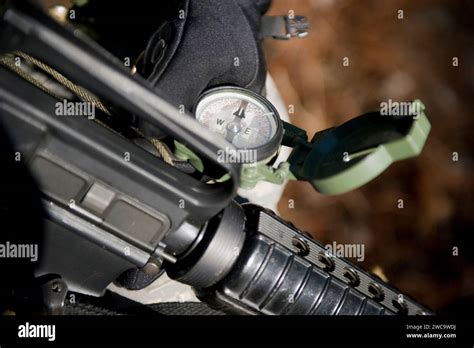 A Soldier Uses A Compass To Navigate Through The Woods During A Field
