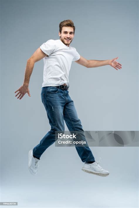 캐주얼 티셔츠 블레이저와 청바지에 재미 남자의 전체 길이 사진 실행 또는 회색 배경 위에 고립 된 공기에서 점프 T 셔츠에 대한 스톡 사진 및 기타 이미지 Istock