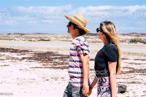 젊은 관광객 부부는 백고룬드에서 푸른 하늘과 해변에서 사랑과 관계에 손을 잡고 산책 여행과 여름 휴가 사람들의 개념 20 29세에 대한 스톡 사진 및 기타 이미지 Istock