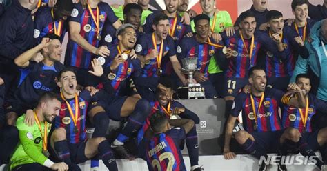 우승컵 놓고 환호하는 바르셀로나 선수들