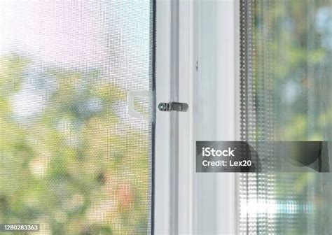 여름에 곤충과 벌레로부터 집을 보호하기 위해 모기장 비행 화면 곤충 장벽이있는 플라스틱 창문에 클로즈업 모기장에 대한 스톡 사진