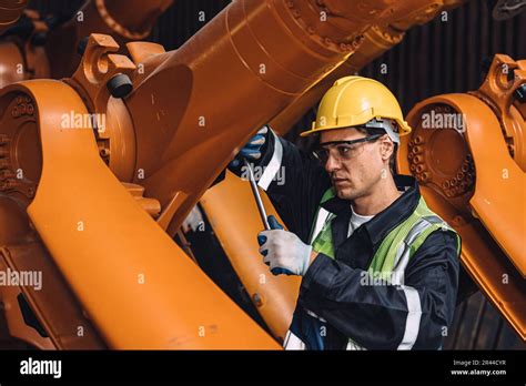 Engineer Working Service Maintenance Robot Arm Welding In Assembly Line