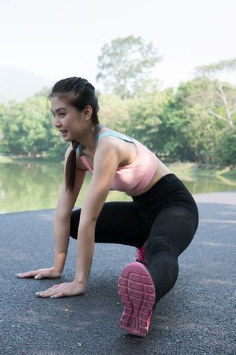 봄이나 여름에 숲 길에서 야외 조깅을 준비하는 여성 스포츠 피트니스 러너 건강 한 젊은 아시아 여자 스트레칭 실행 하기 전에 또는 공원에서 운동 후 건강한 생활방식에 대한