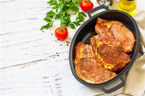 신선한 생 돼지 허리는 향신료와 양념장으로 나무 테이블에 주철 냄비에 양념하여 베이킹을 준비합니다 공간을 복사합니다 돼지고기에 대한 스톡 사진 및 기타 이미지 Istock