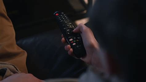 premium stock video person clicking buttons on a remote