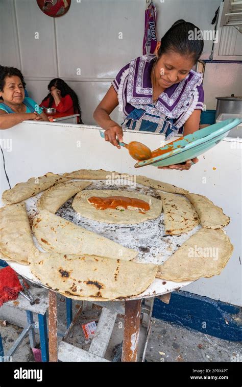 A Young Indigenous Zapotec Woman Makes Yellow Mole Empanadas On A Comal