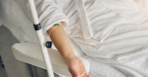 미용 시술 중 정맥에 바늘을 꽂고 침대에 누워 있는 여성 환자의 자른 사진 사진 Unsplash의 진료소 이미지