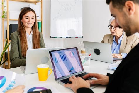 Business Team Analyzing Charts And Data On Laptops In Office Meeting Stock Image Image Of