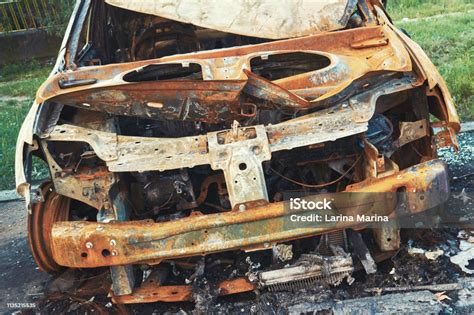 대도시의 거리에 있는 공공 주차장에서 격렬 한 화재로 고통을 겪은 승용차를 태워 손상 된 차량 표면 깨진 바람막이 주차장에 입사