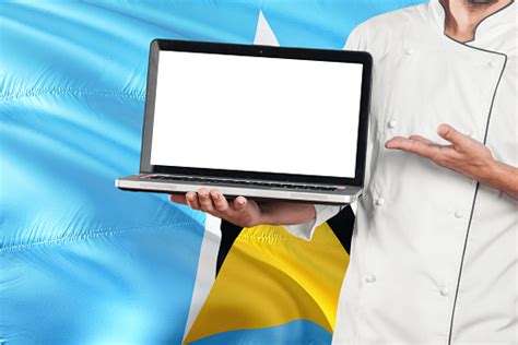 세인트 루시아 국기 배경에 빈 화면으로 노트북을 들고 요리사 복사 공간에 대 한 유니폼과 포인팅 노트북을 입고 요리 고급 요리에 대한 스톡 사진 및 기타 이미지 Istock