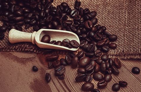 갈색의 오래된 나무 테이블에 구운 콩의 삼베 자루가있는 커피 컵 0명에 대한 스톡 사진 및 기타 이미지 0명