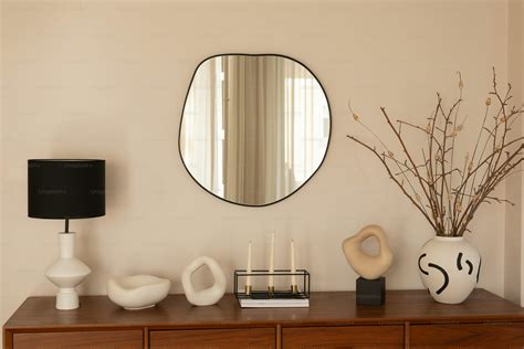 거울 꽃병 그 위에 램프가 있는 서랍장 사진 Unsplash의 내부 이미지