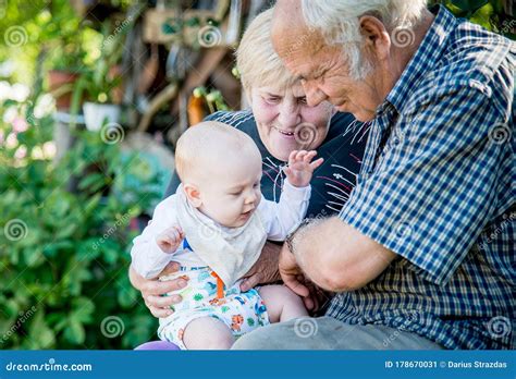 Бабушки и дедушки и семья внука счастливой улыбкой Стоковое